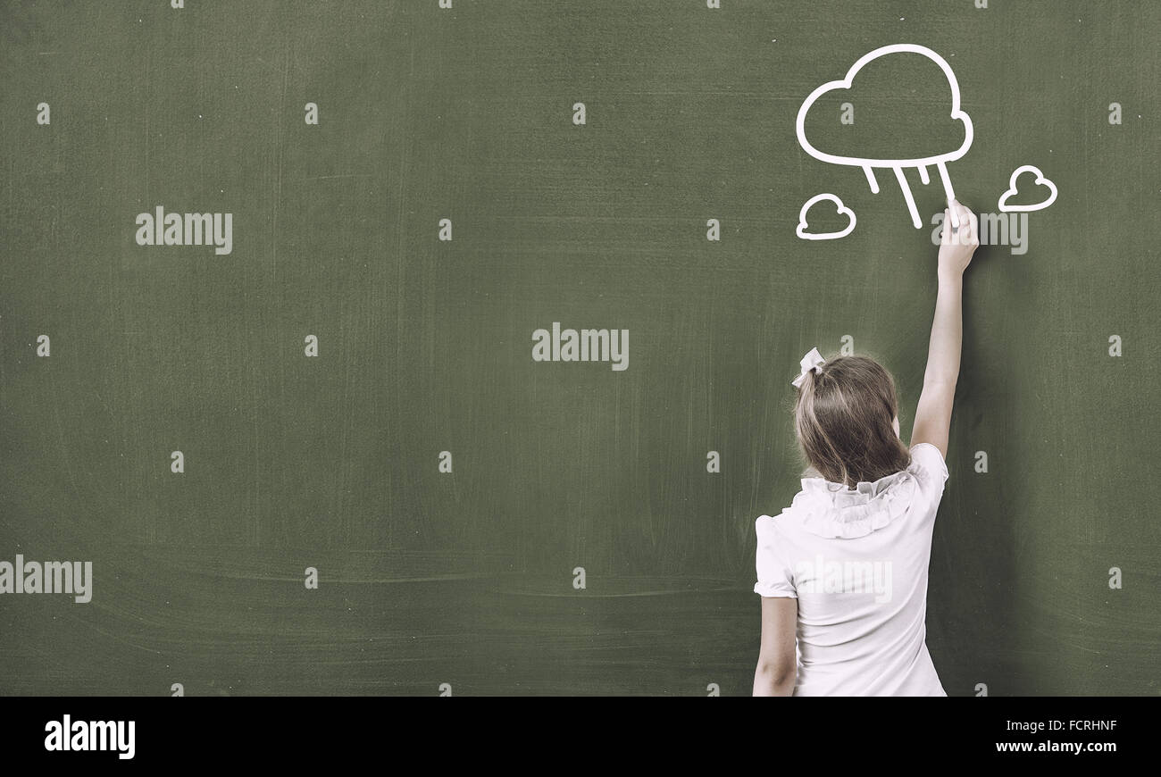 Pretty girl of school age standing at blackboard Stock Photo - Alamy