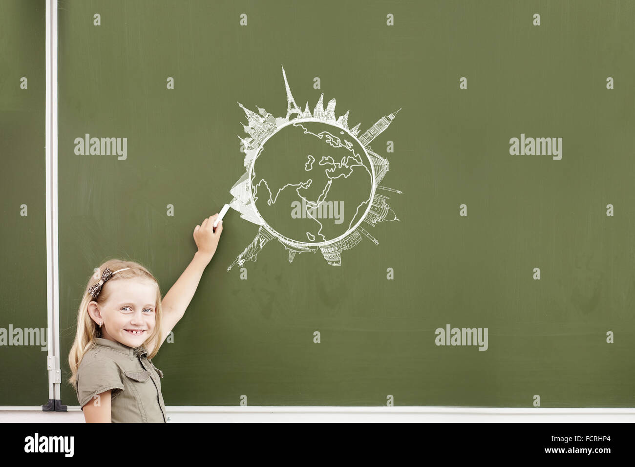 Cute girl of school age writing with chalk on blackboard Stock Photo ...