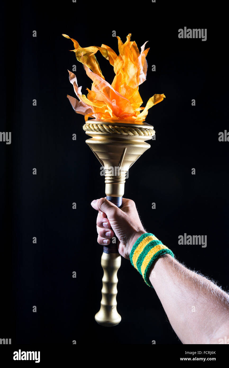 Hand of Brazilian athlete holding sport torch against a black ...