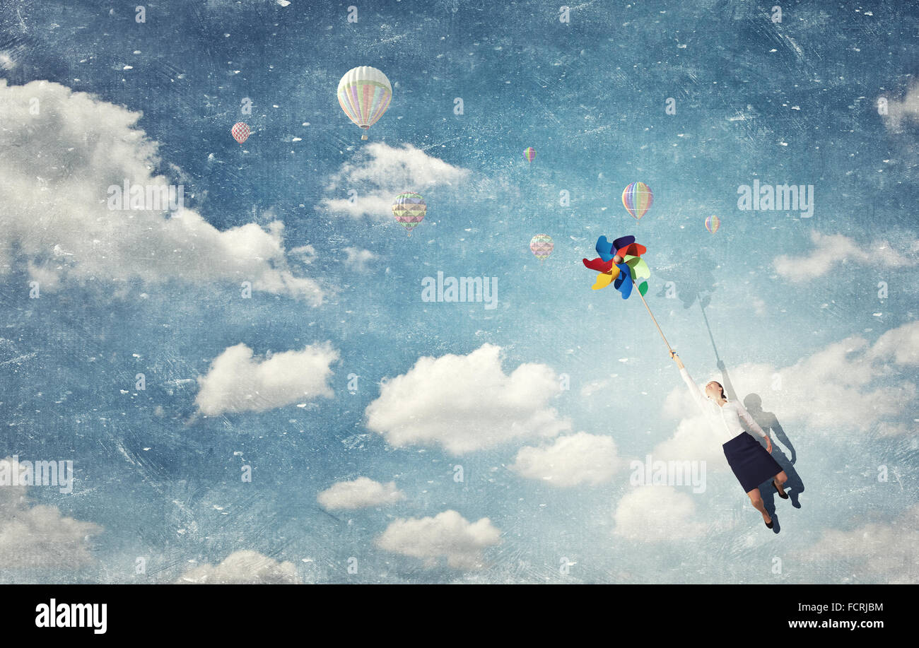 Beautiful young caucasian businesswoman flying on windmill Stock Photo ...