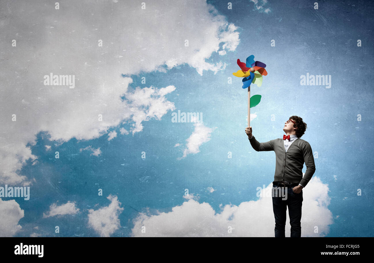 Young happy businessman with colorful windmill in hand Stock Photo - Alamy