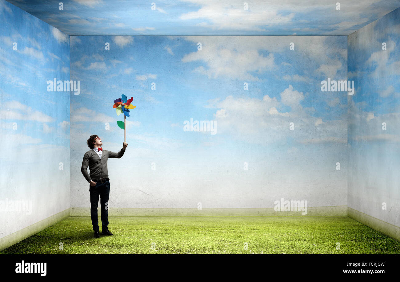 Young happy businessman with colorful windmill in hand Stock Photo - Alamy