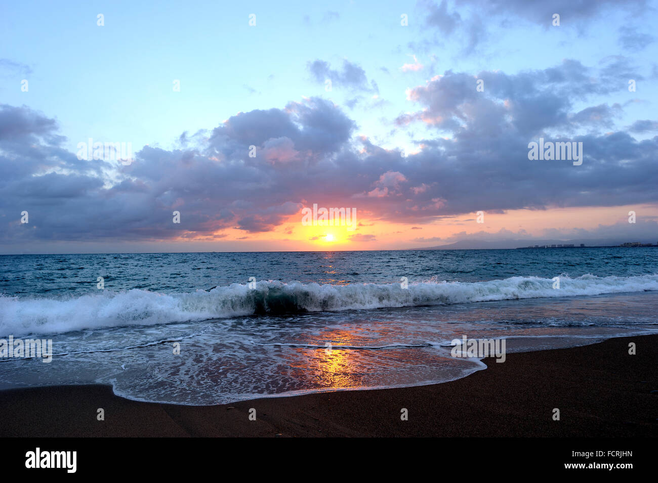 Ocean sunset is a sunset on the beach with a wave breaking on shore and ...