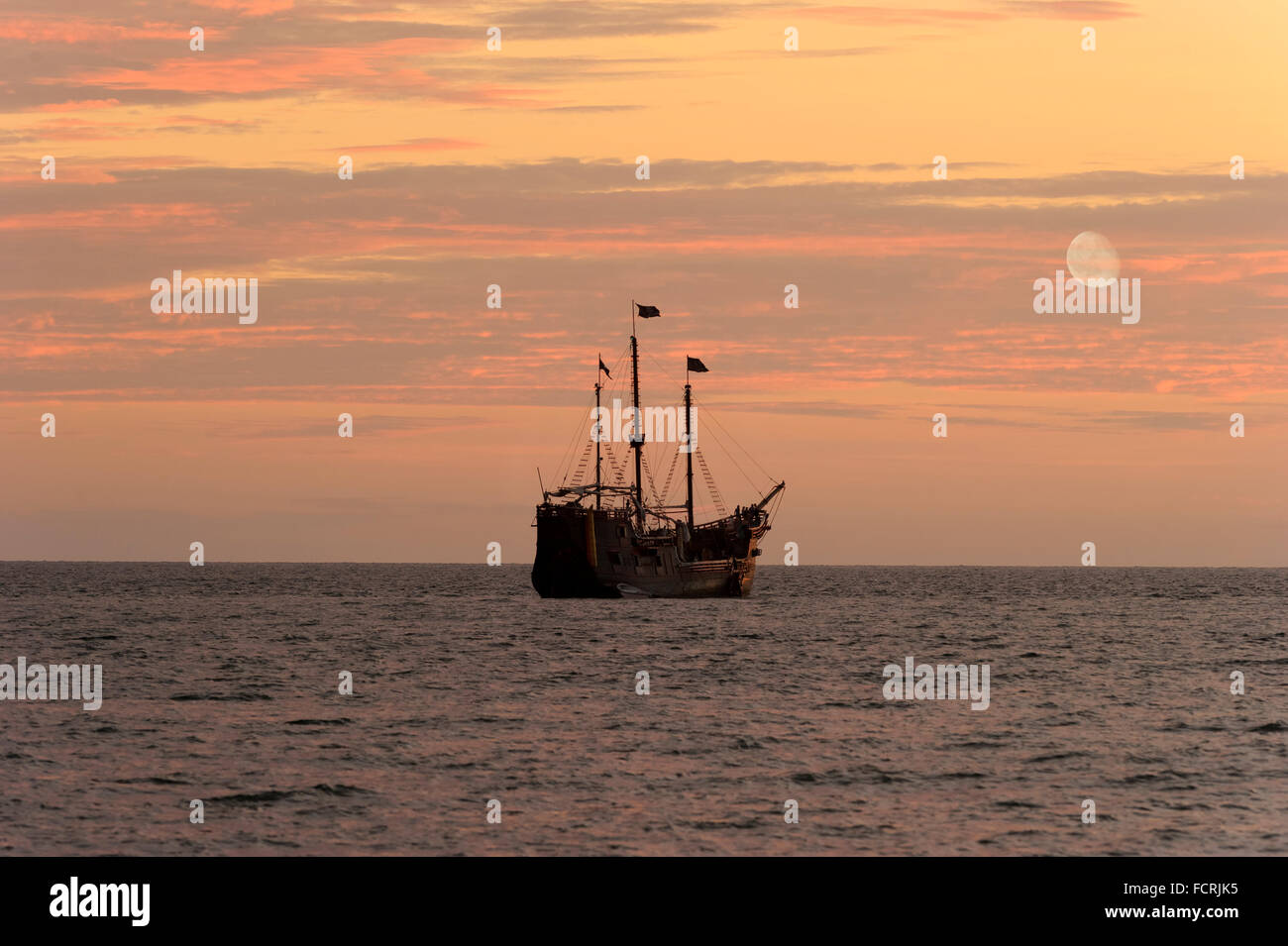 Pirate Ship is a pirate ship out at sea with the moon rising in the ...