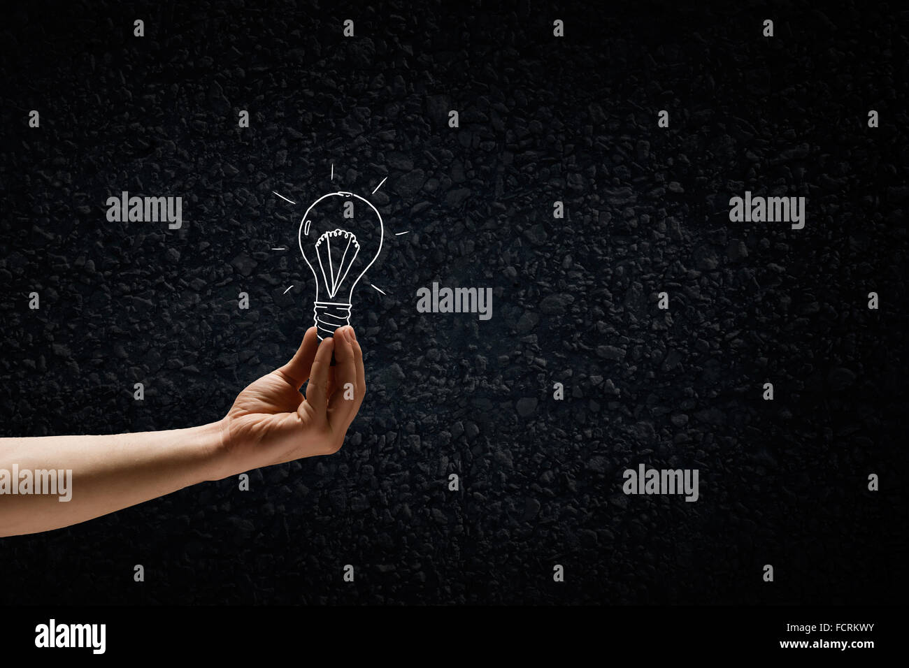 Human hand on dark background holding light bulb Stock Photo - Alamy