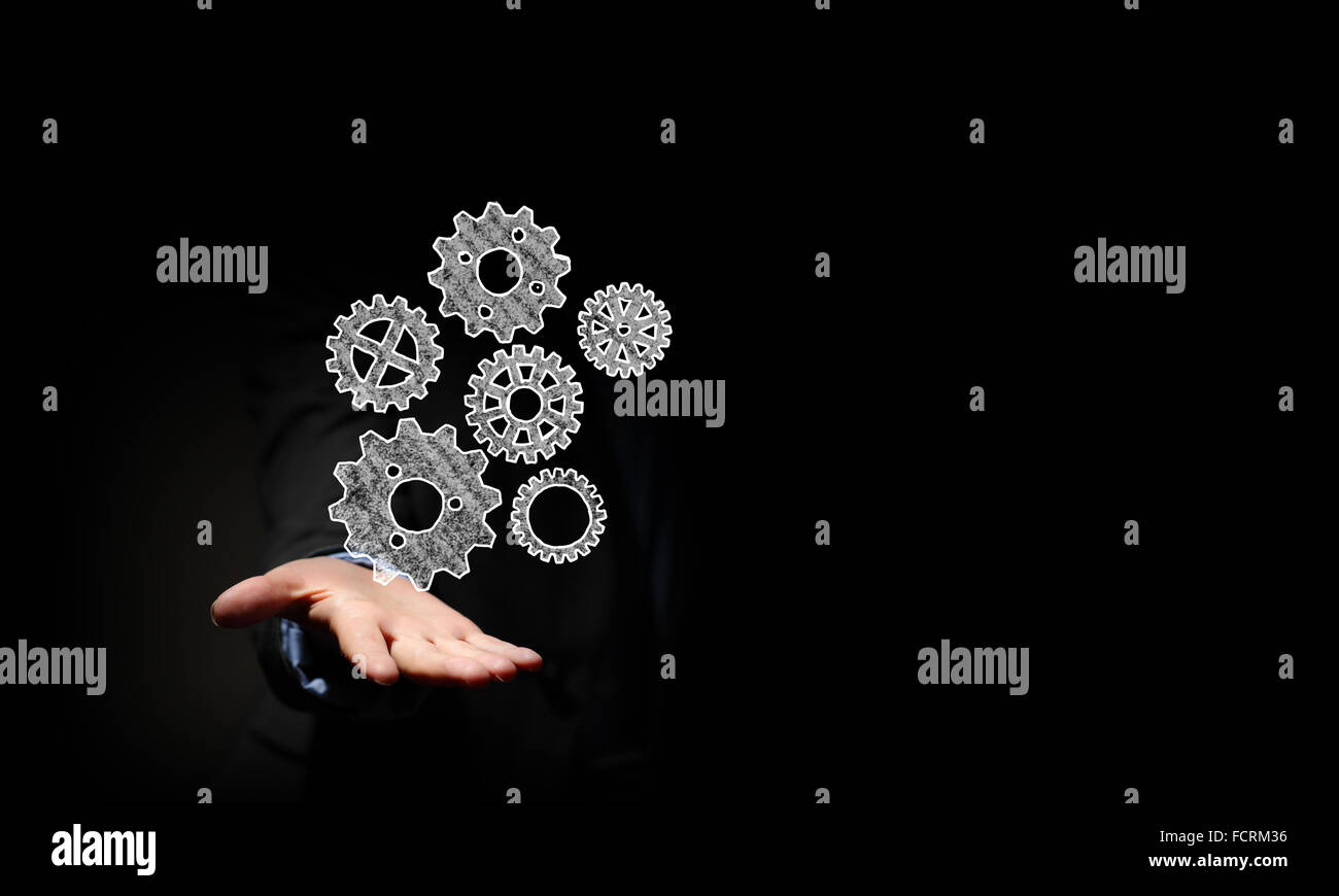 Close up of human hand holding gears engine Stock Photo - Alamy