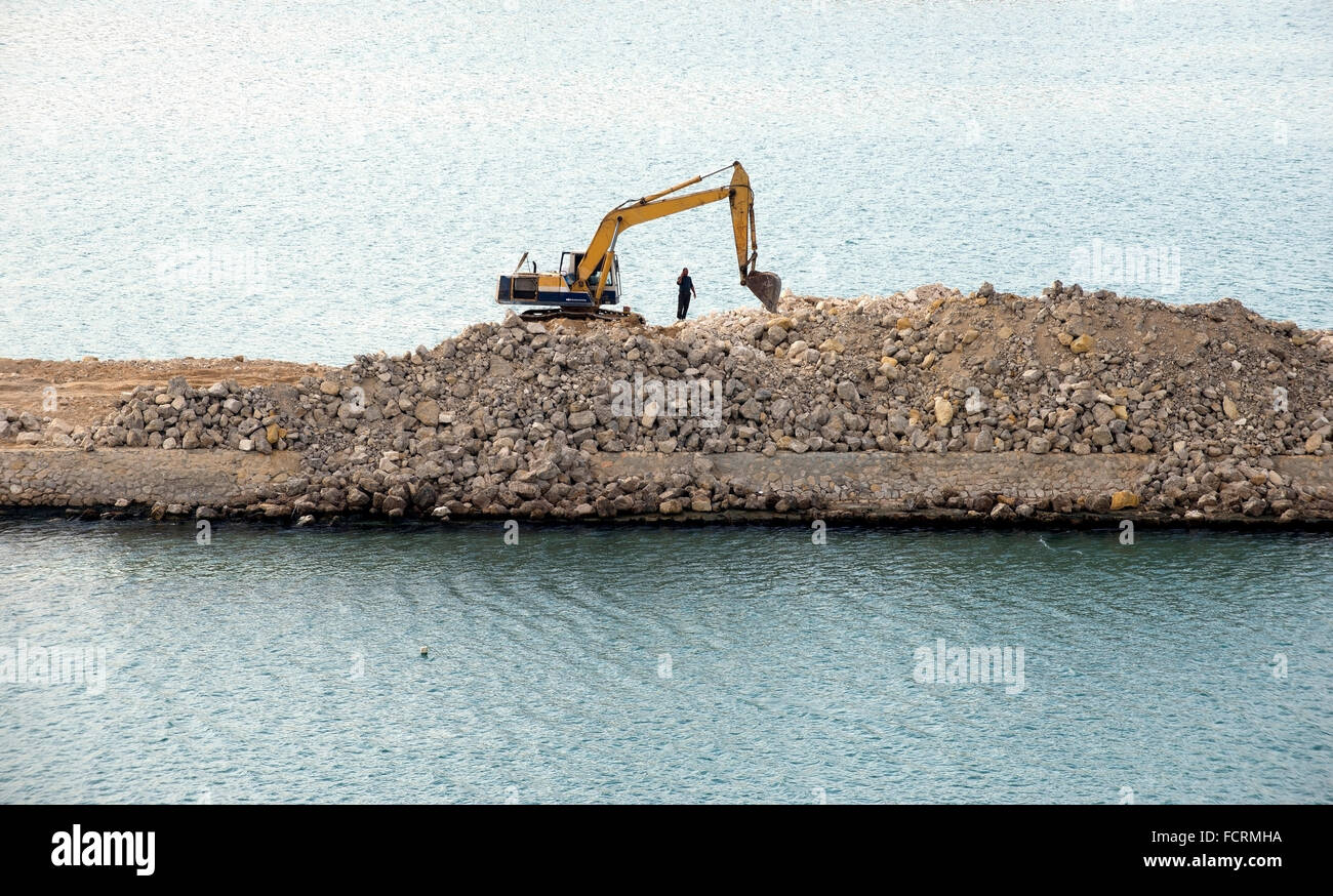 Construction labourer stands under the caterpillar while the bulldozer ...