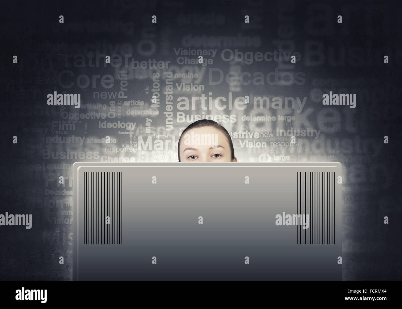 Young woman looking out above laptop monitor Stock Photo - Alamy