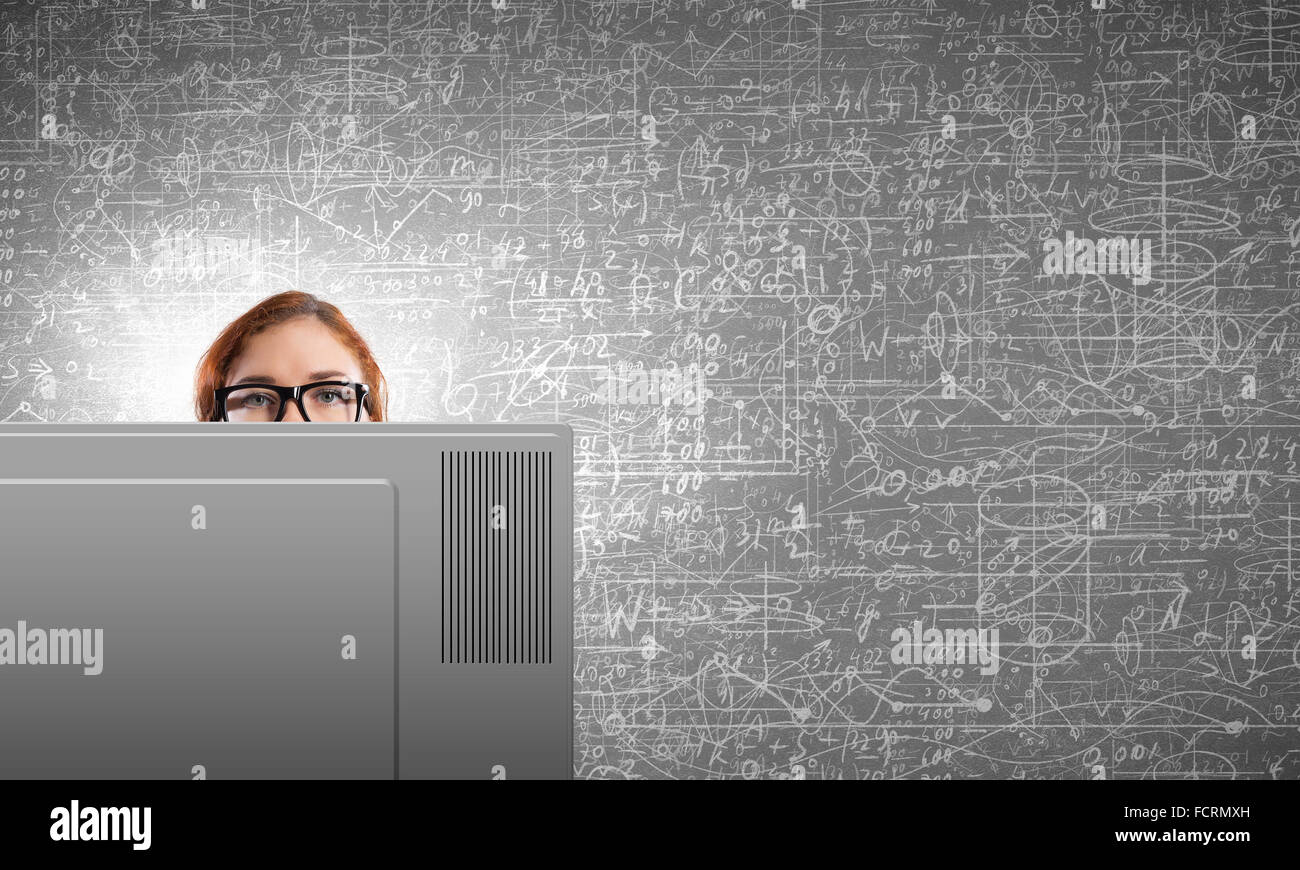 Young woman looking out above laptop monitor Stock Photo - Alamy