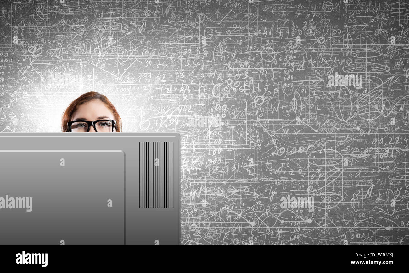 Young woman looking out above laptop monitor Stock Photo - Alamy