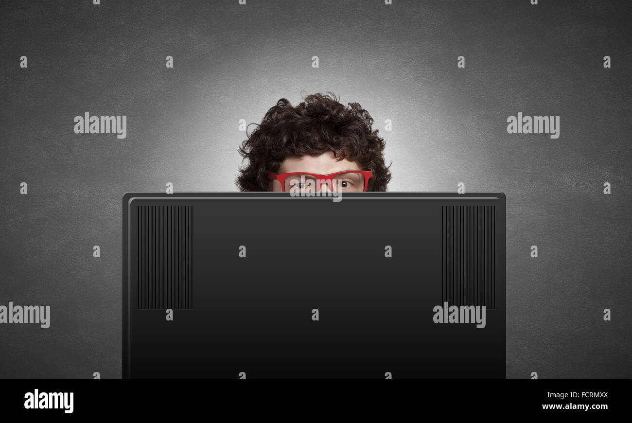 Young man looking out above laptop monitor Stock Photo - Alamy