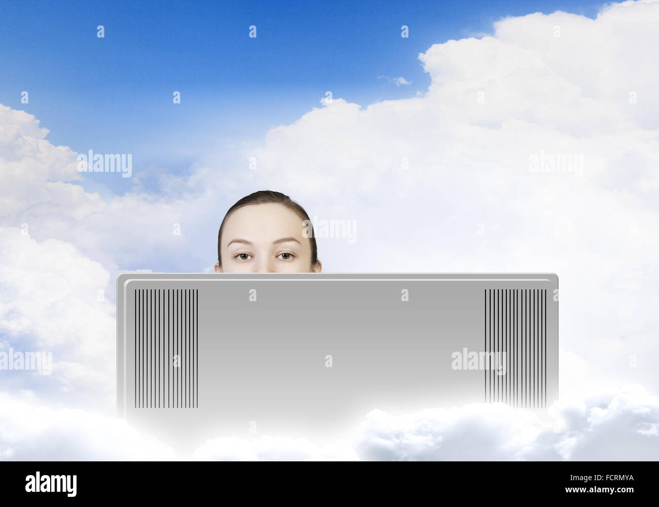 Young woman looking out above laptop monitor Stock Photo - Alamy