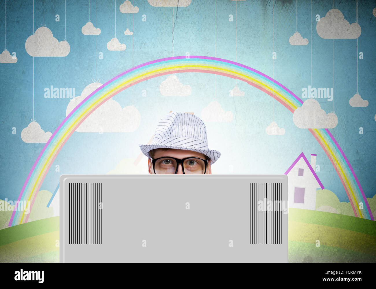 Young man looking out above laptop monitor Stock Photo - Alamy
