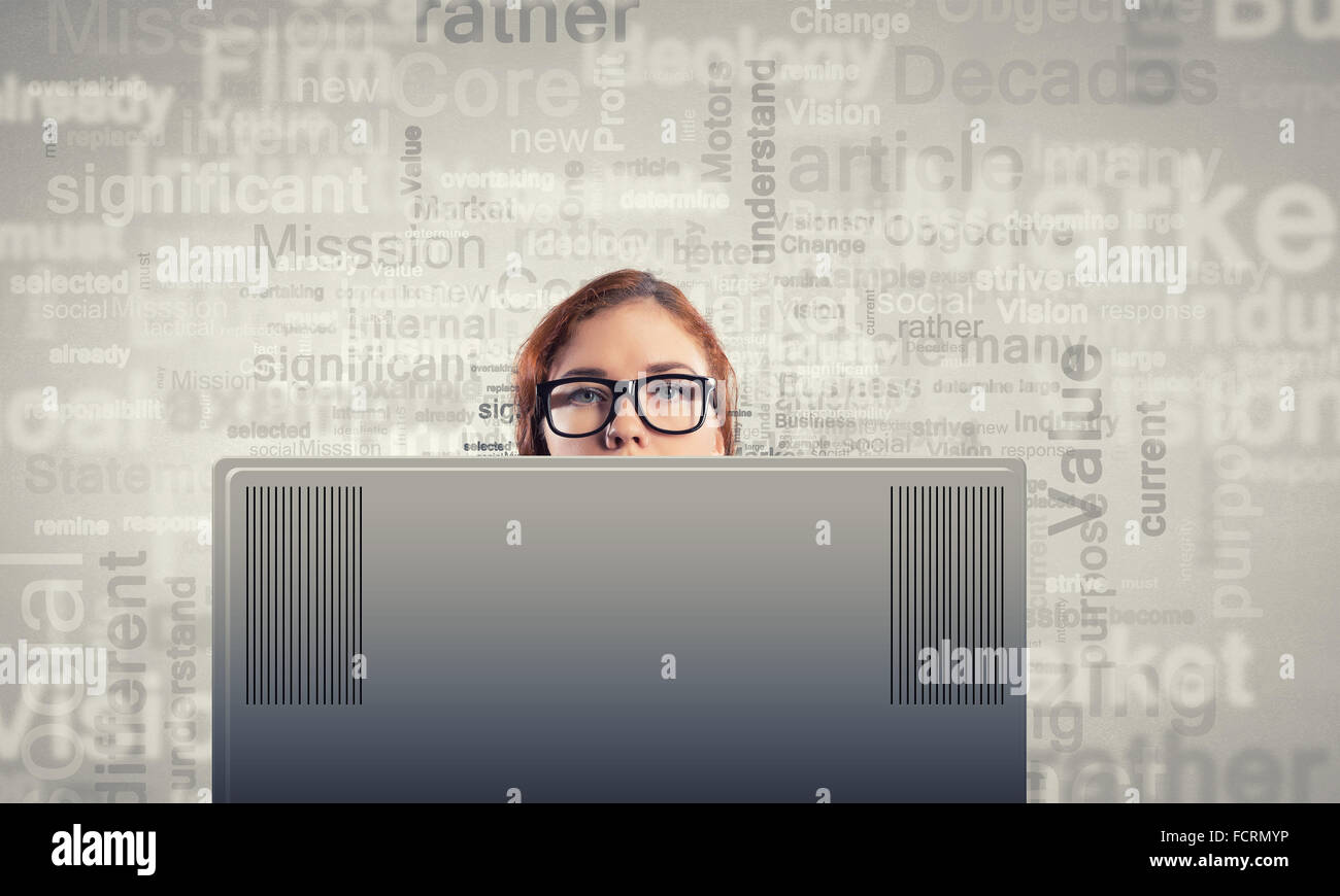 Young woman looking out above laptop monitor Stock Photo - Alamy