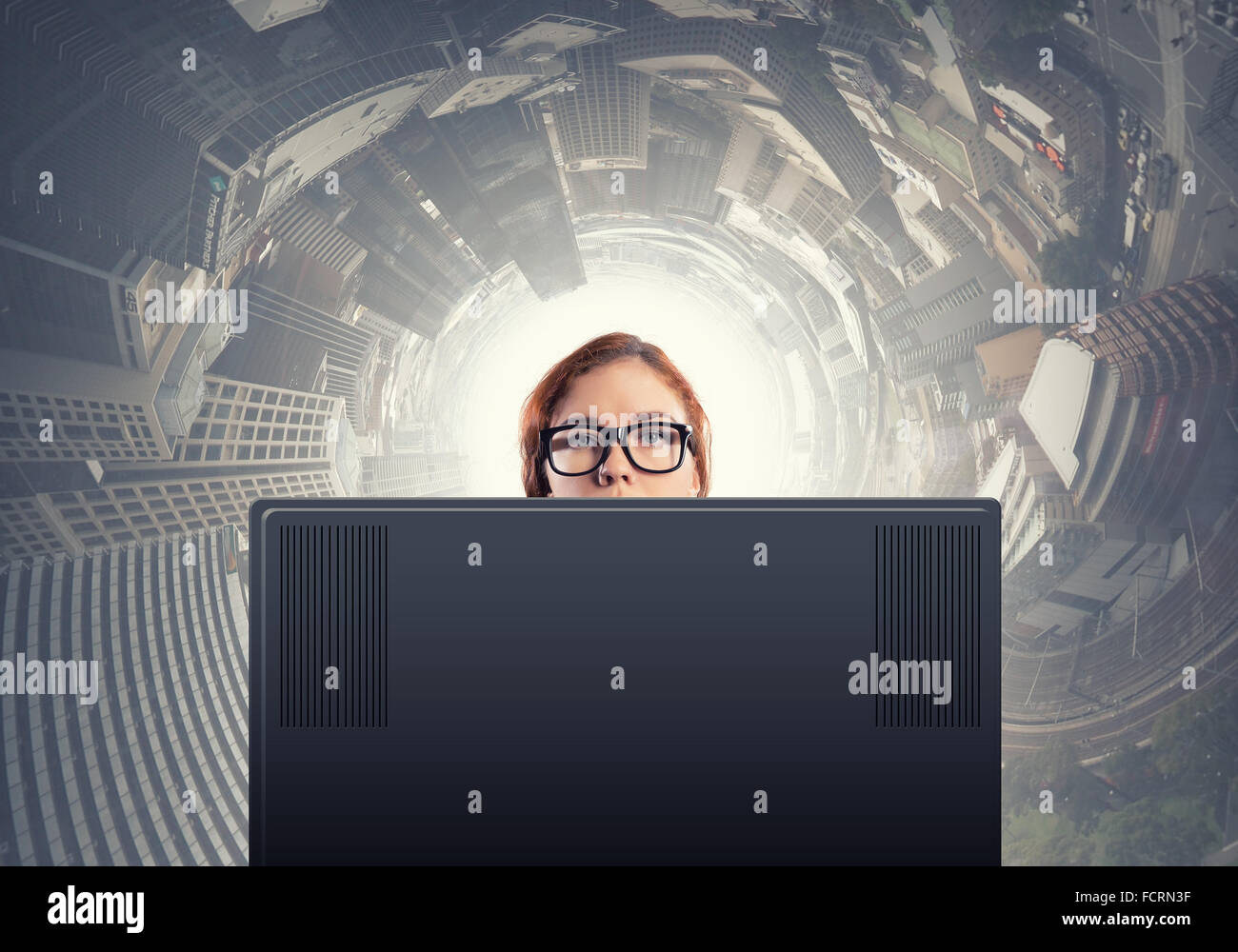Young woman looking out above laptop monitor Stock Photo - Alamy