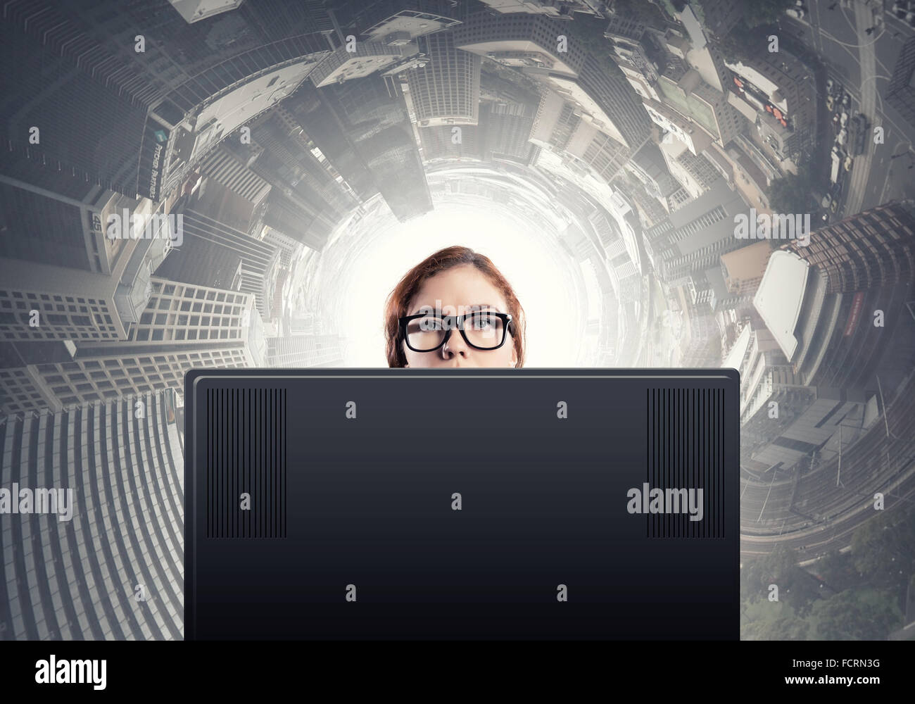 Young woman looking out above laptop monitor Stock Photo - Alamy
