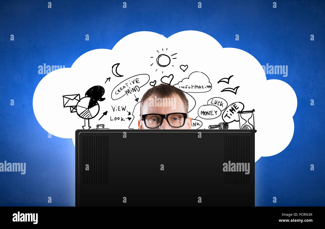 Young man looking out above laptop monitor Stock Photo - Alamy