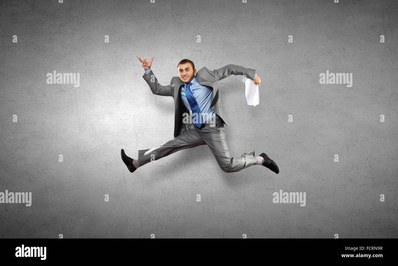 Young speedy businessman running in a hurry Stock Photo - Alamy