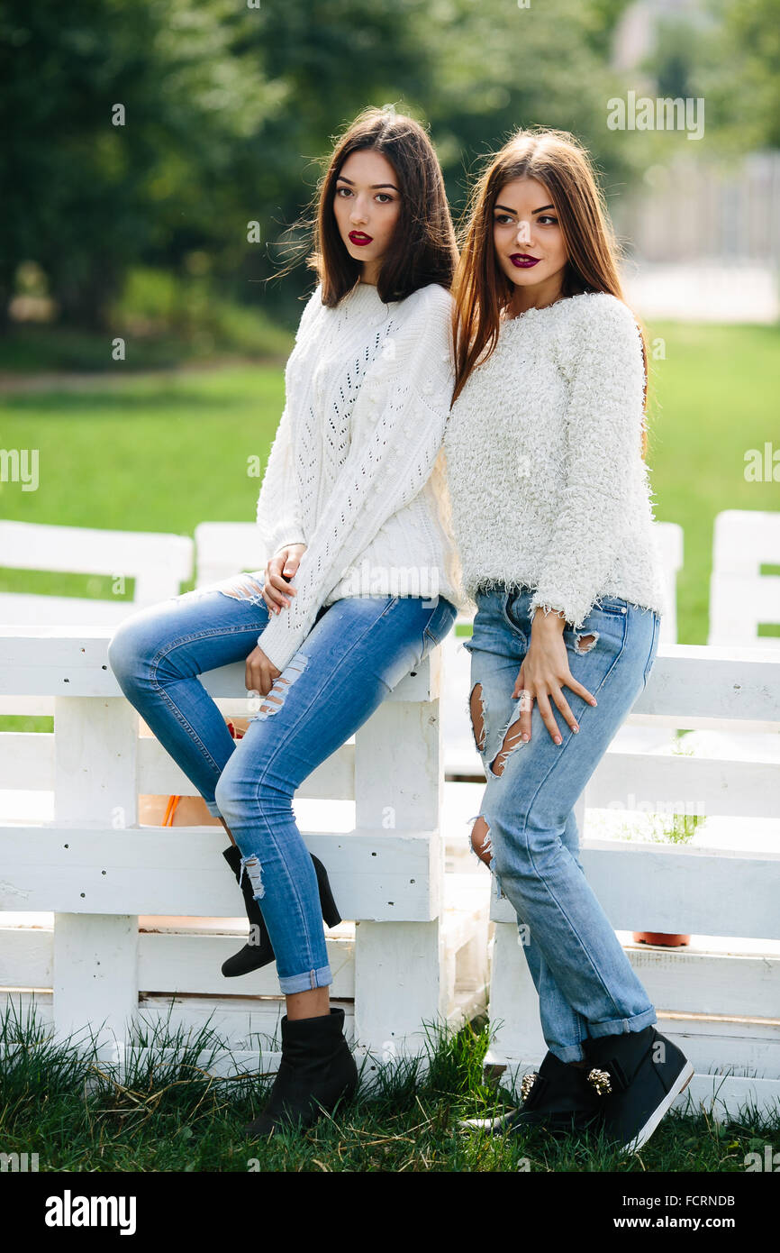 Two girls lean bench Stock Photo - Alamy