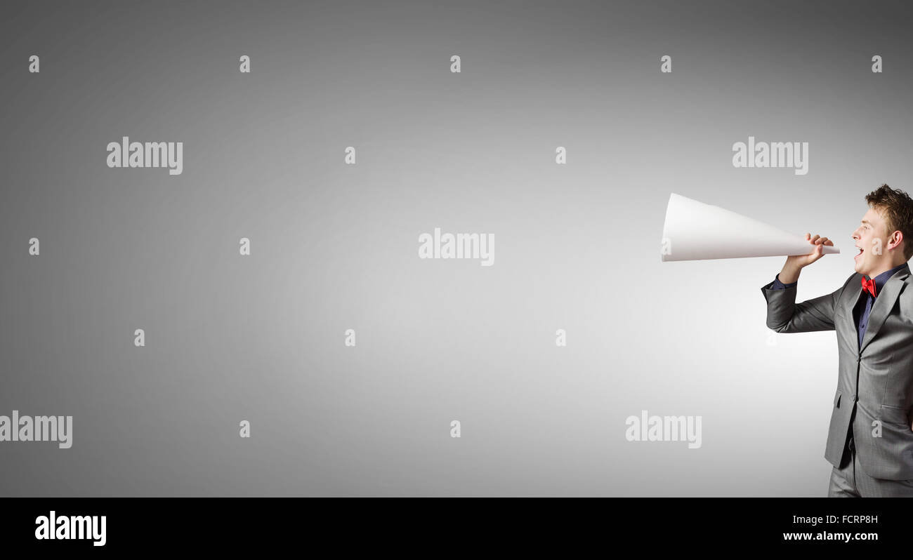 Young man making some announcement in trumpet Stock Photo - Alamy