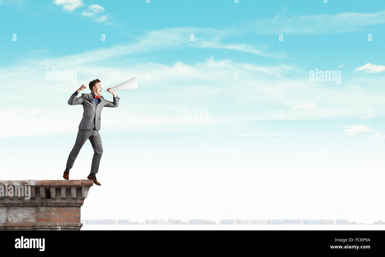 Young man making some announcement in trumpet Stock Photo - Alamy