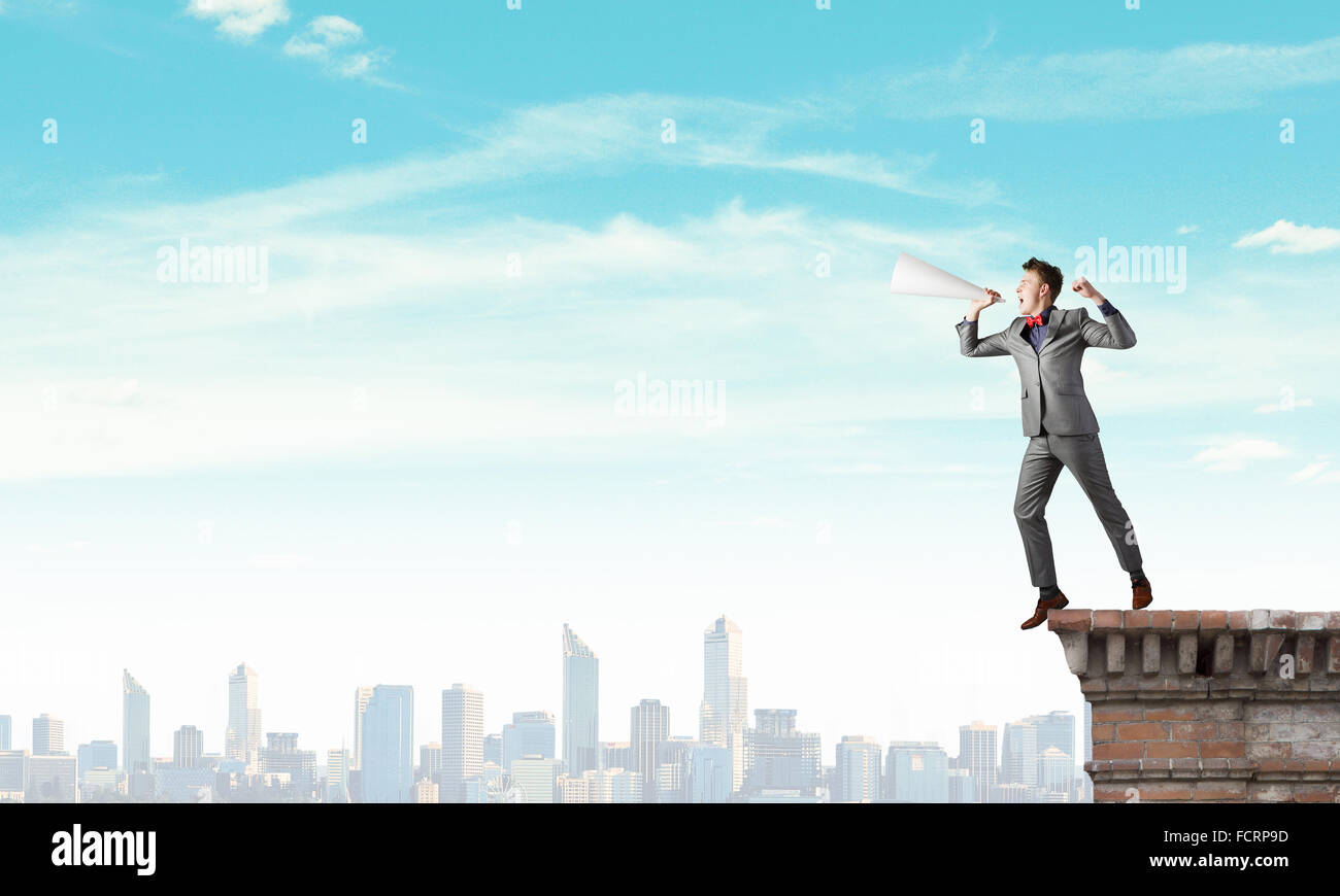 Young man making some announcement in trumpet Stock Photo - Alamy