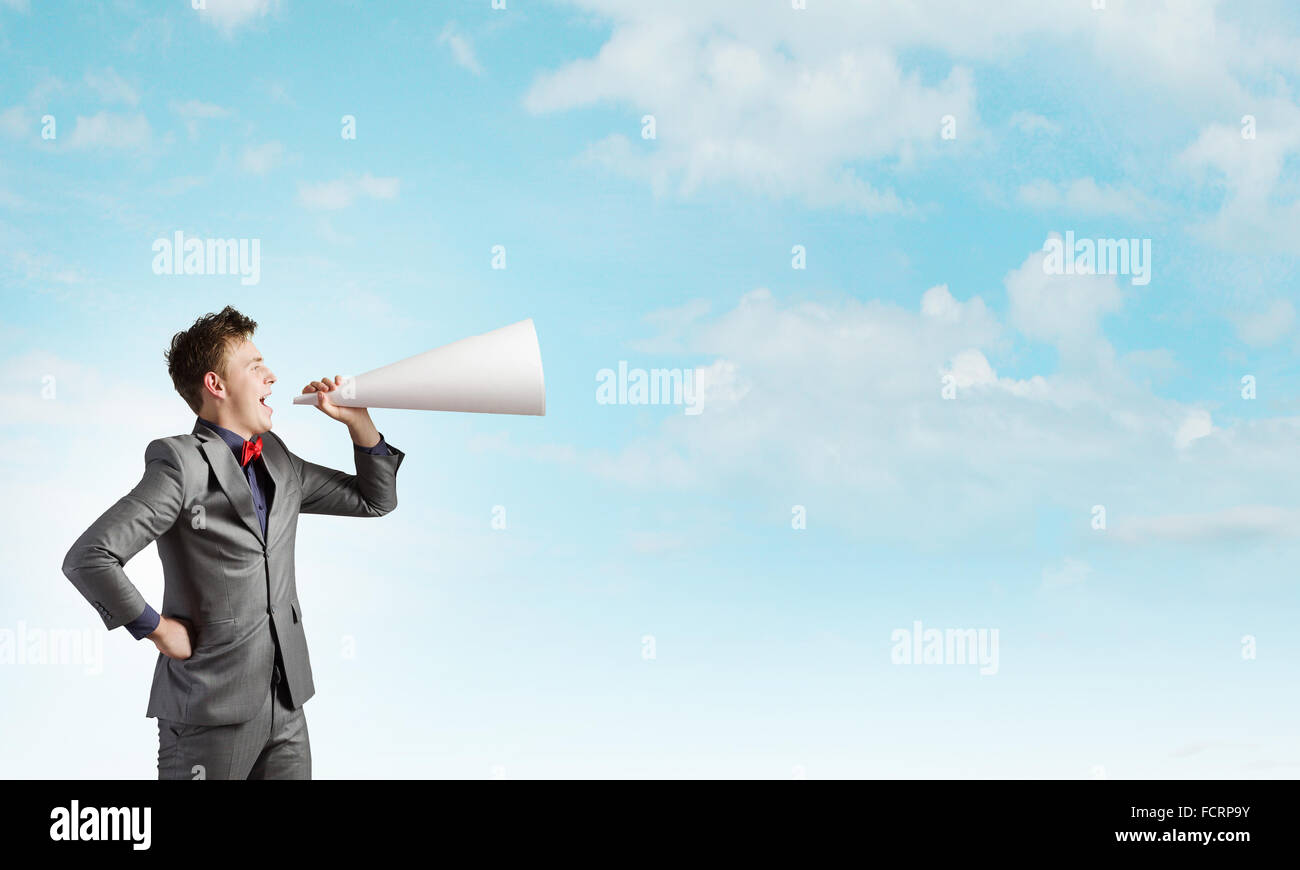 Young man making some announcement in trumpet Stock Photo - Alamy