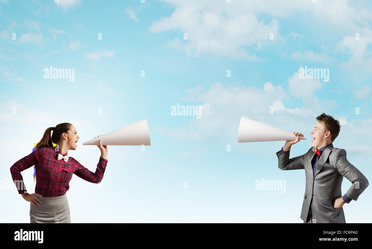 Young people screaming at each other in paper trumpet Stock Photo - Alamy