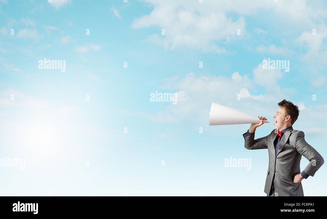 Young man making some announcement in trumpet Stock Photo - Alamy