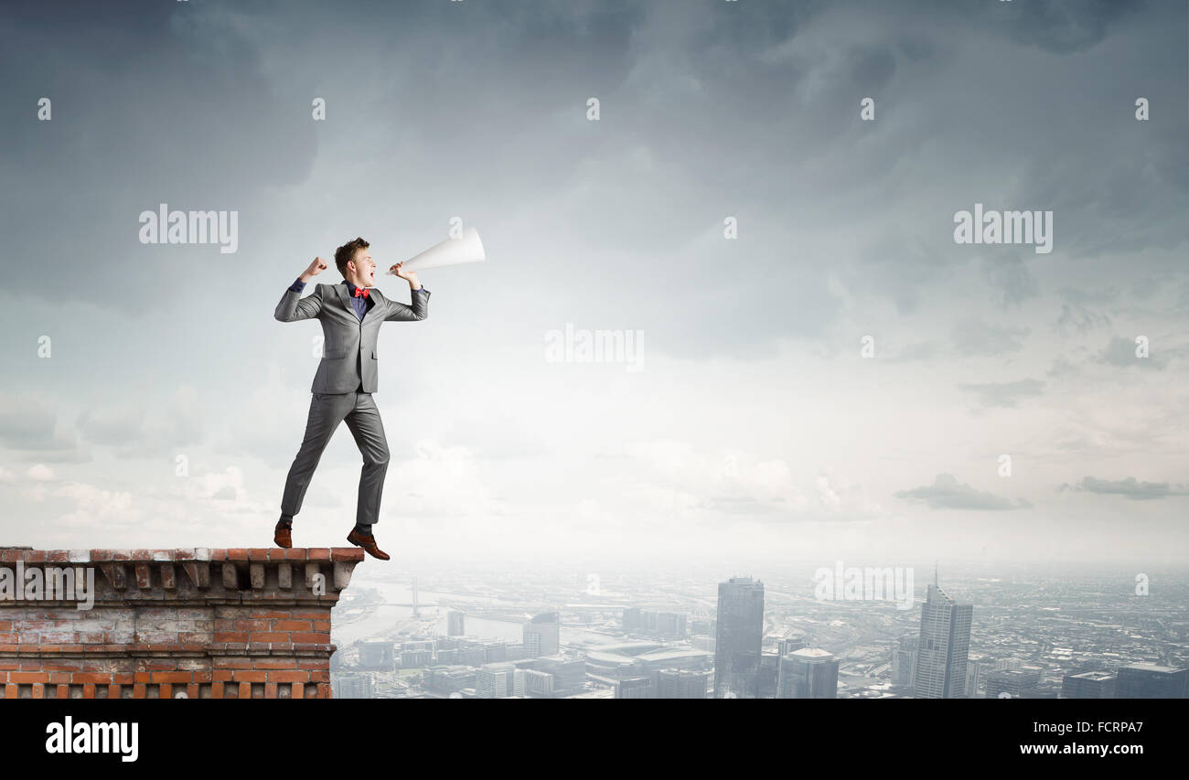 Young man making some announcement in trumpet Stock Photo - Alamy