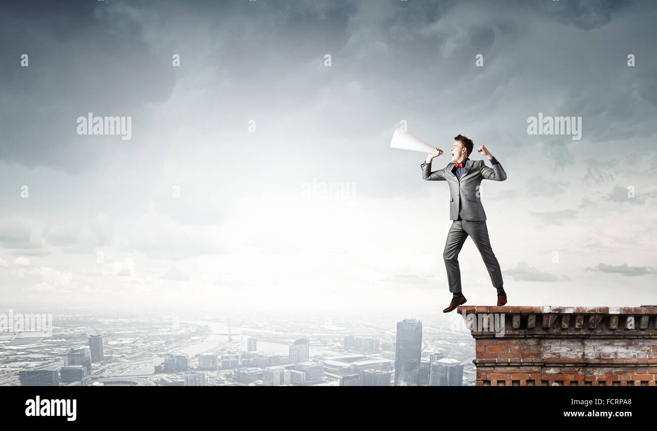 Young man making some announcement in trumpet Stock Photo - Alamy