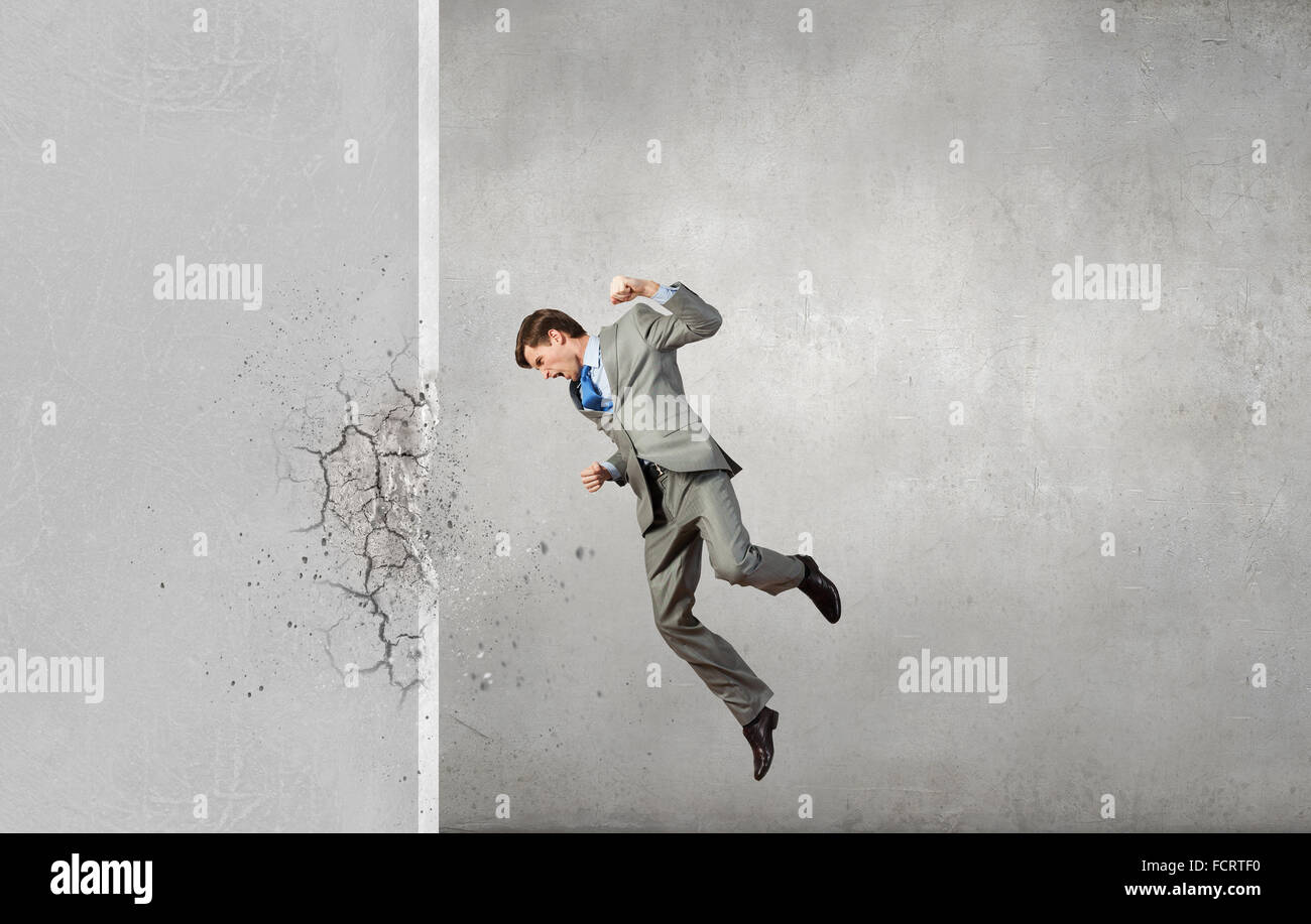Businessman breaking stone wall with karate punch Stock Photo - Alamy