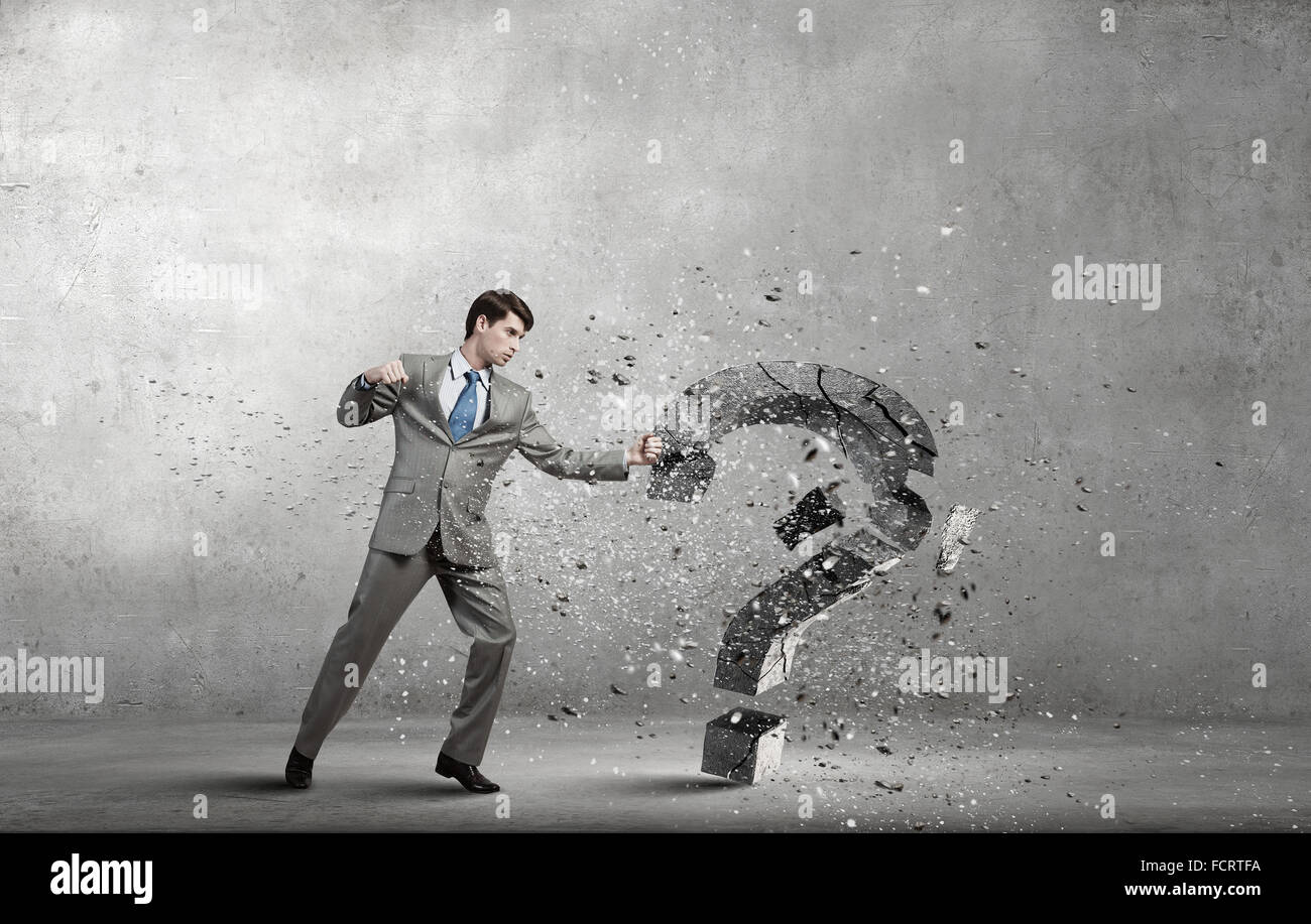 Businessman breaking stone question mark with karate kick Stock Photo ...