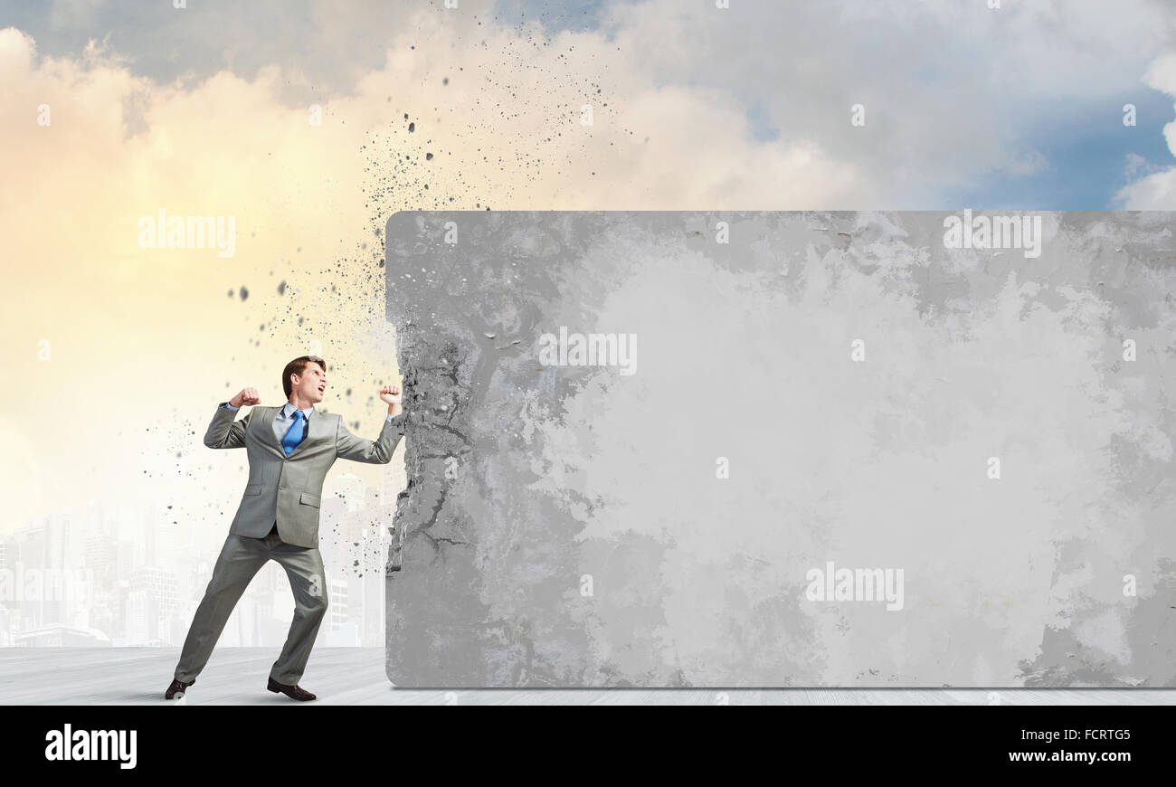 Businessman breaking stone wall with karate punch Stock Photo - Alamy