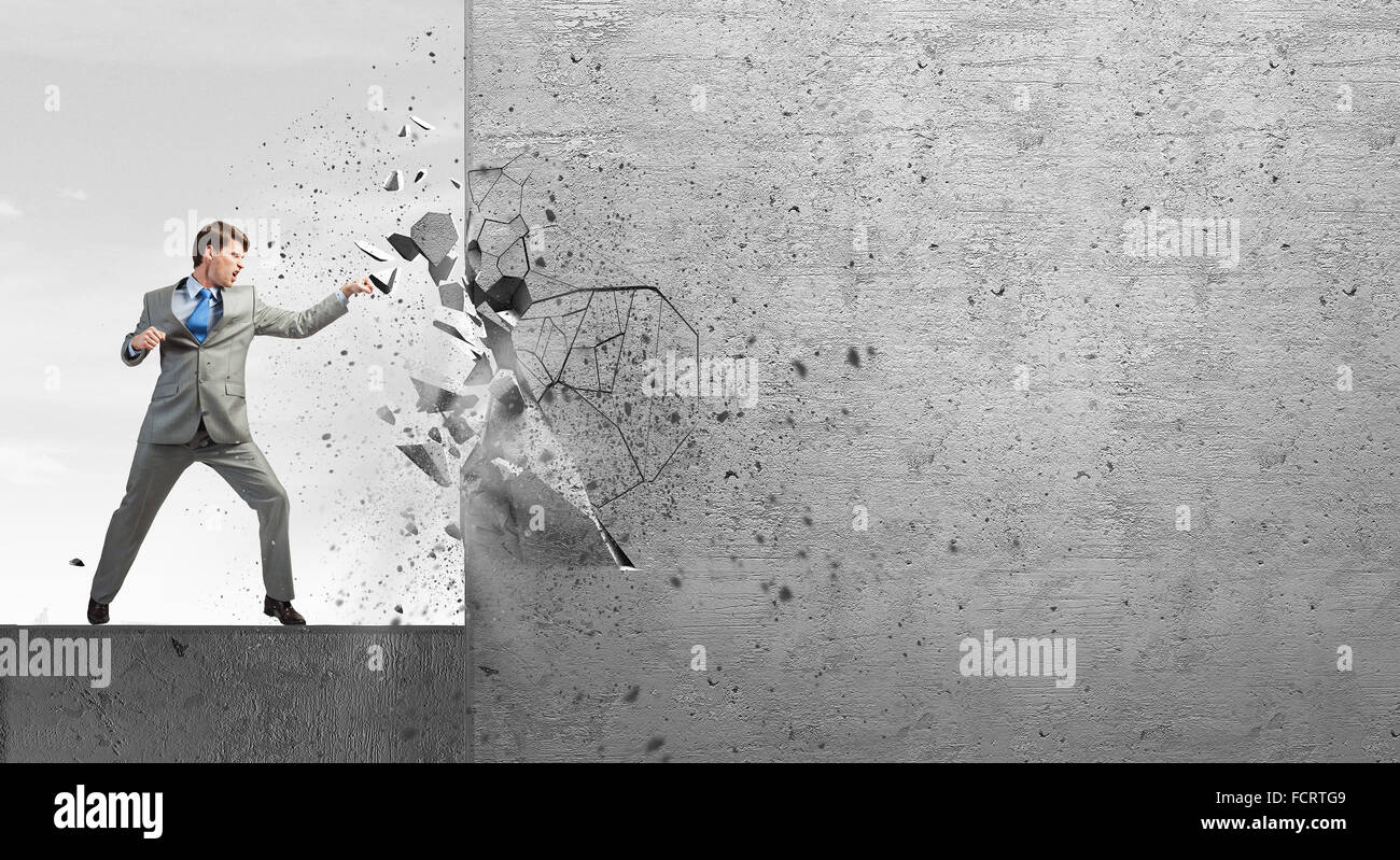 Businessman breaking stone wall with karate punch Stock Photo - Alamy