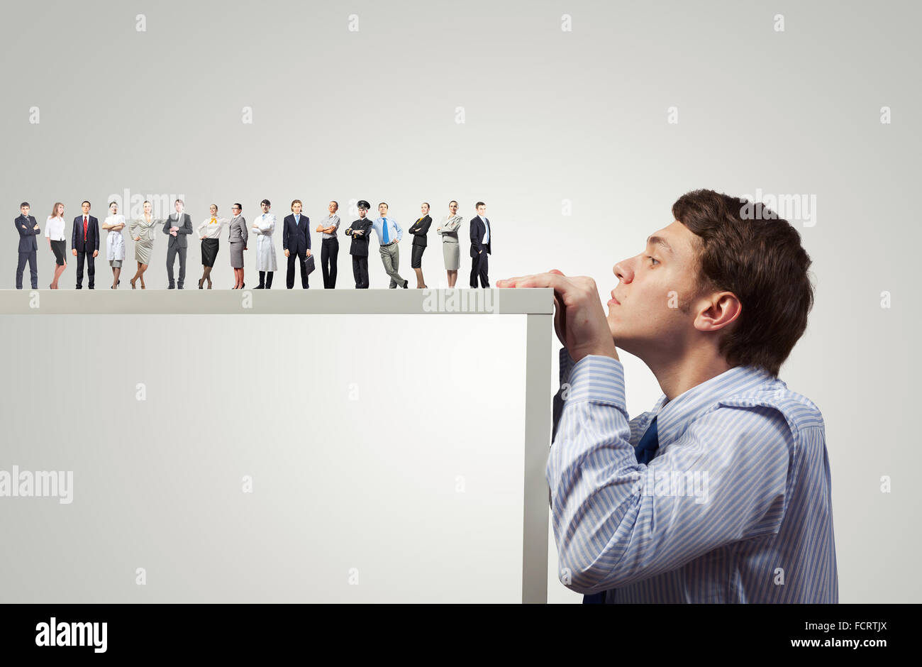 Young man looking from under table on large group of business people ...