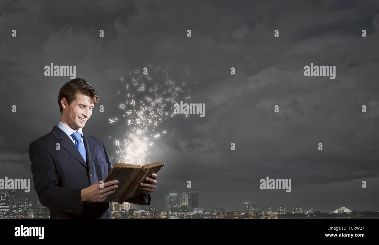 Young handsome man in suit reading old book Stock Photo - Alamy