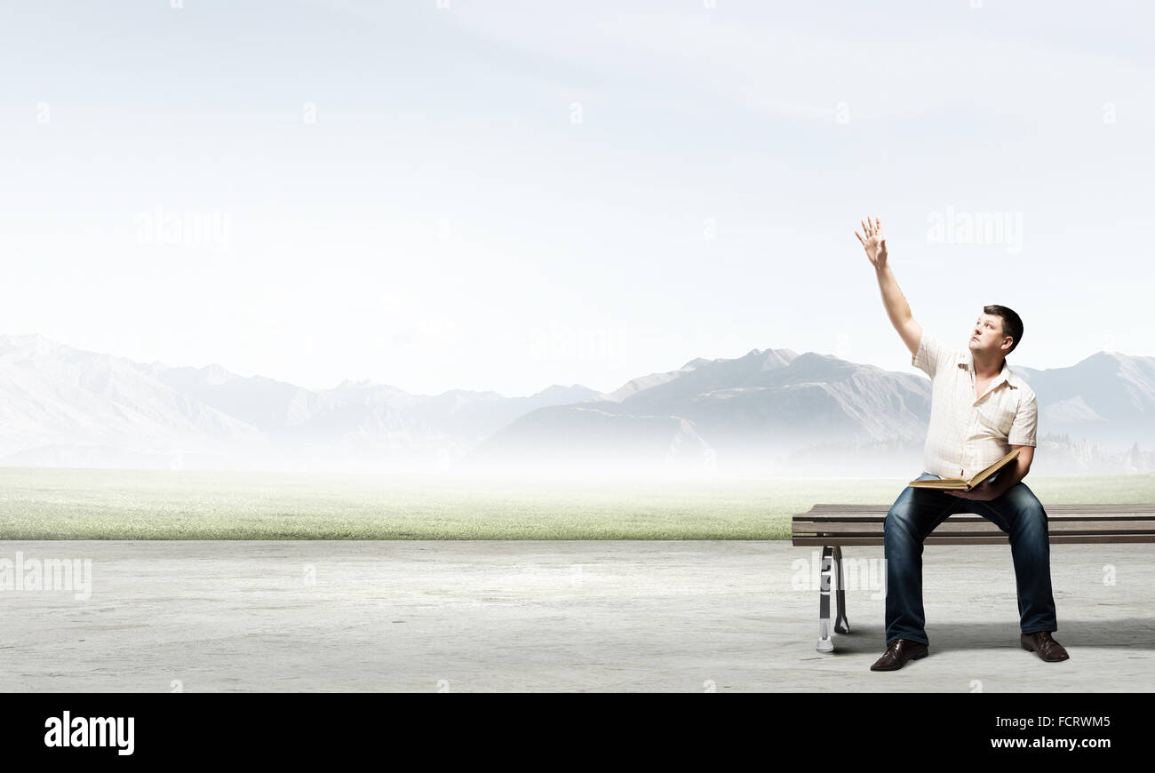 Fat man sitting on bench with book and reaching hand Stock Photo - Alamy