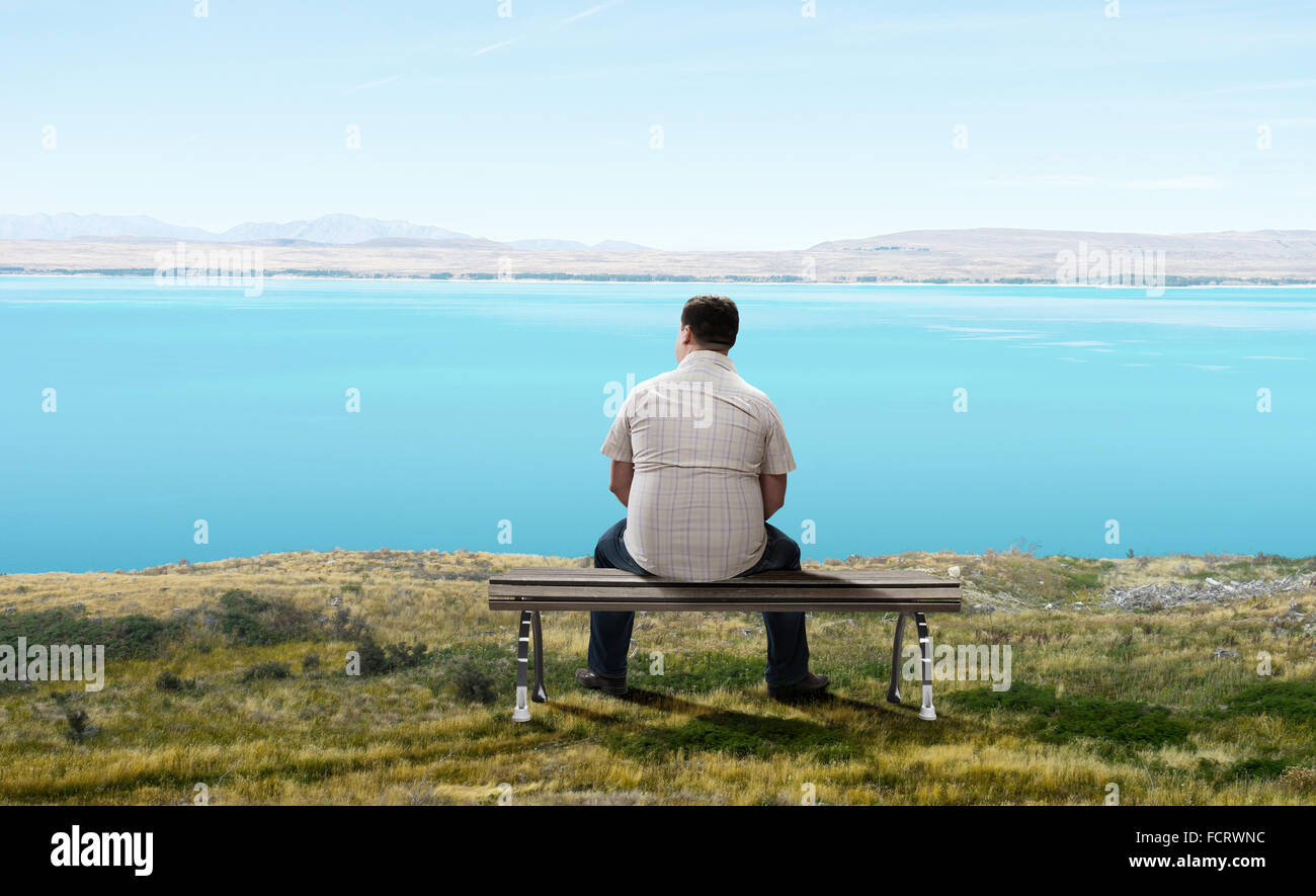 Fat man sitting on bench with his back and looking away Stock Photo - Alamy