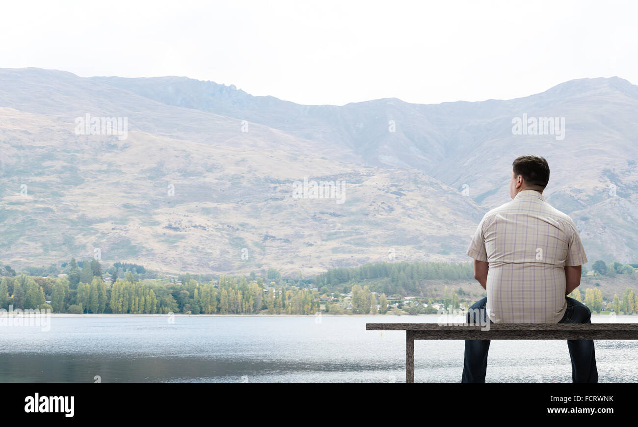 Fat man sitting on bench with his back and looking away Stock Photo - Alamy