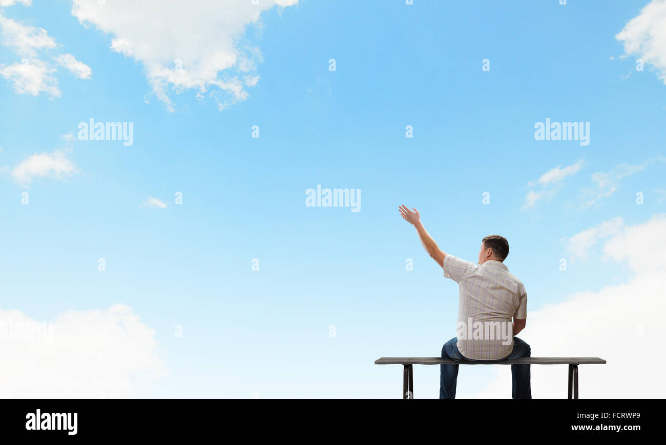 Fat man sitting on bench with his back and looking away Stock Photo - Alamy