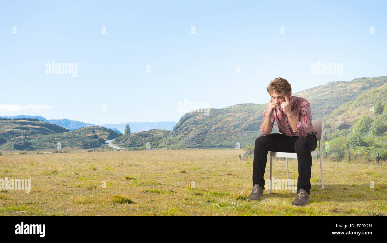 Depressed man sitting on a chair all alone Stock Photo - Alamy