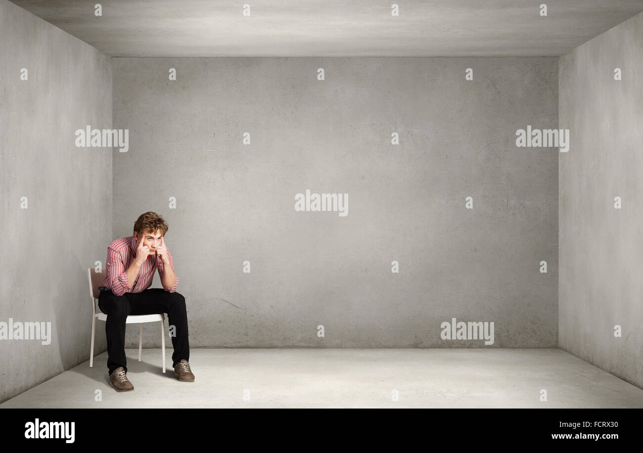 Depressed man sitting on a chair all alone Stock Photo - Alamy