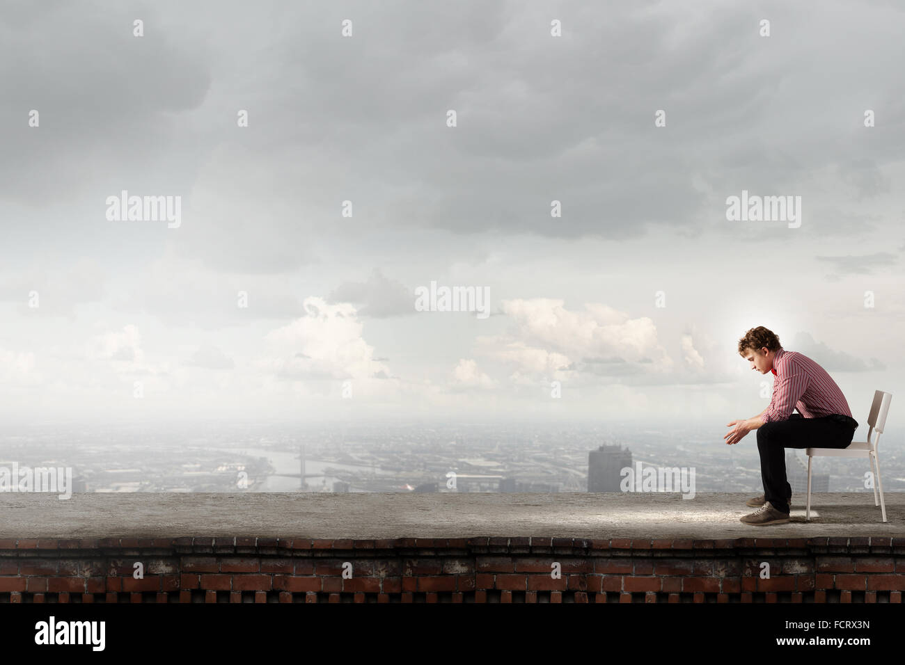 Depressed man sitting on a chair all alone Stock Photo - Alamy