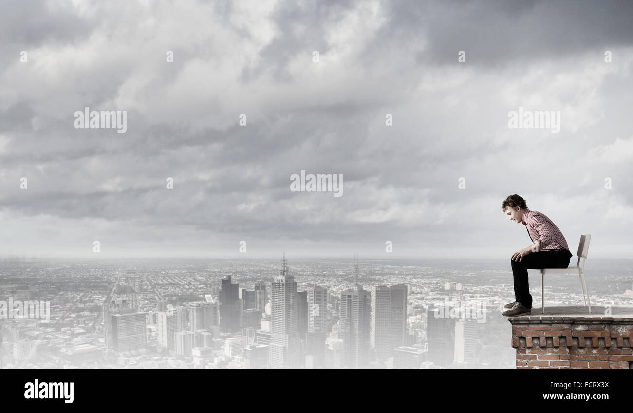 Depressed man sitting on a chair all alone Stock Photo - Alamy