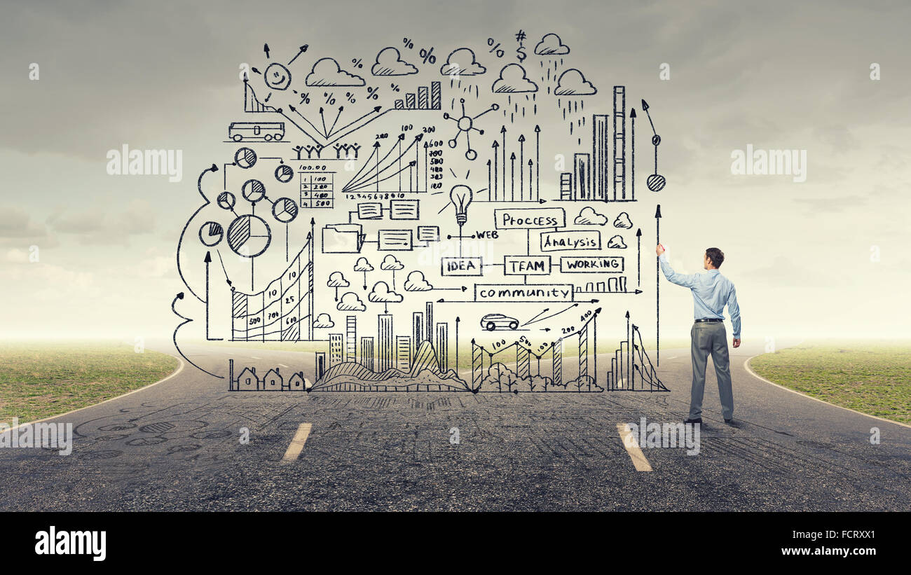 Back view of businessman drawing business sketches on wall Stock Photo ...