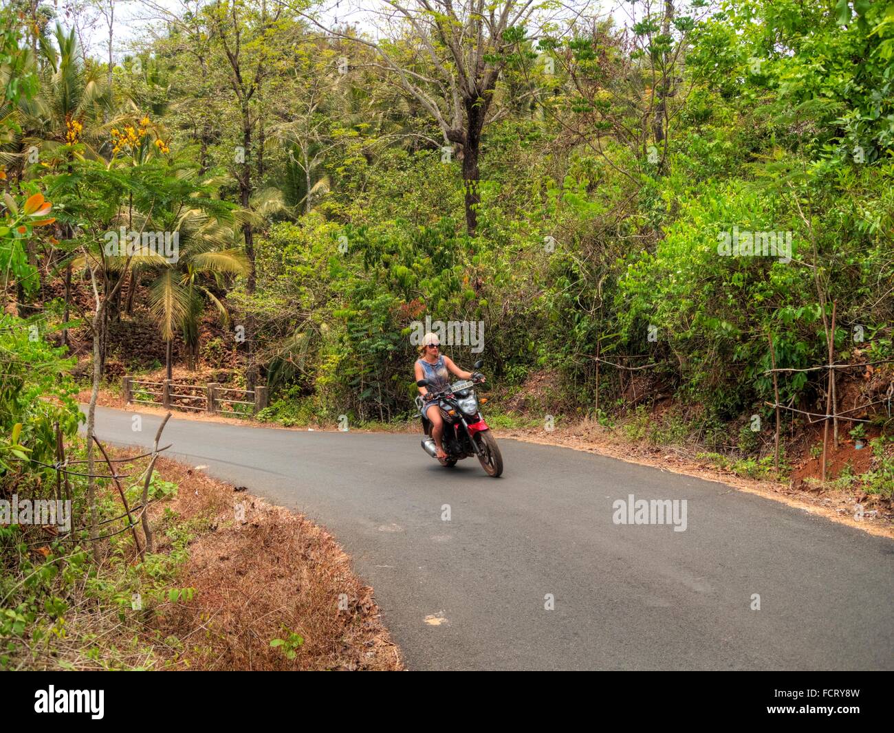 Young Girl Riding Motorbike on Road through Wild Countryside, Goa ...