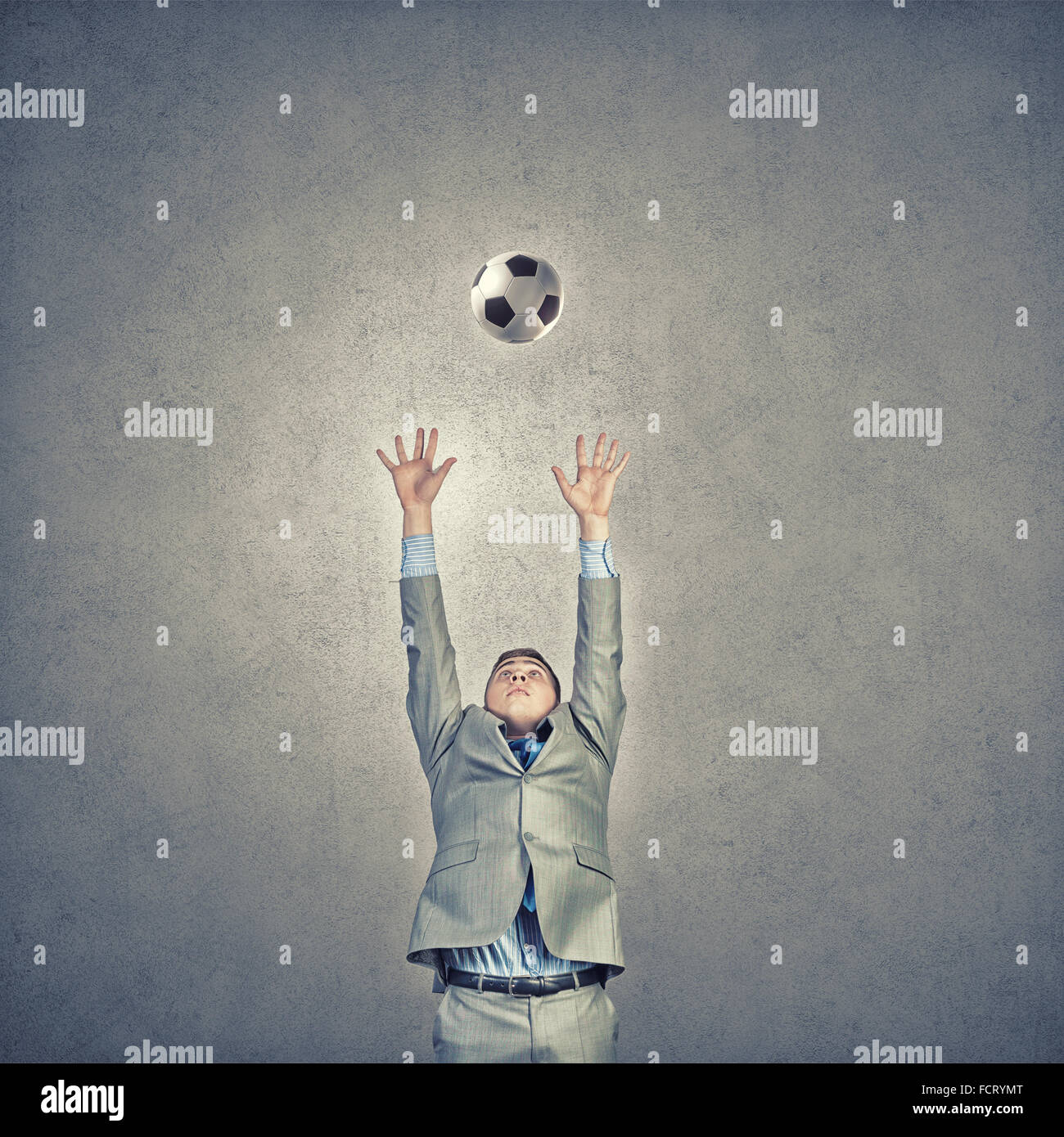 Businessman in suit jumping to hit soccer ball Stock Photo - Alamy