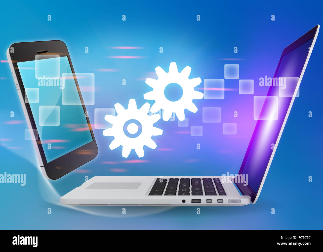 Laptop and phone with gear icon on a blue background Stock Photo - Alamy