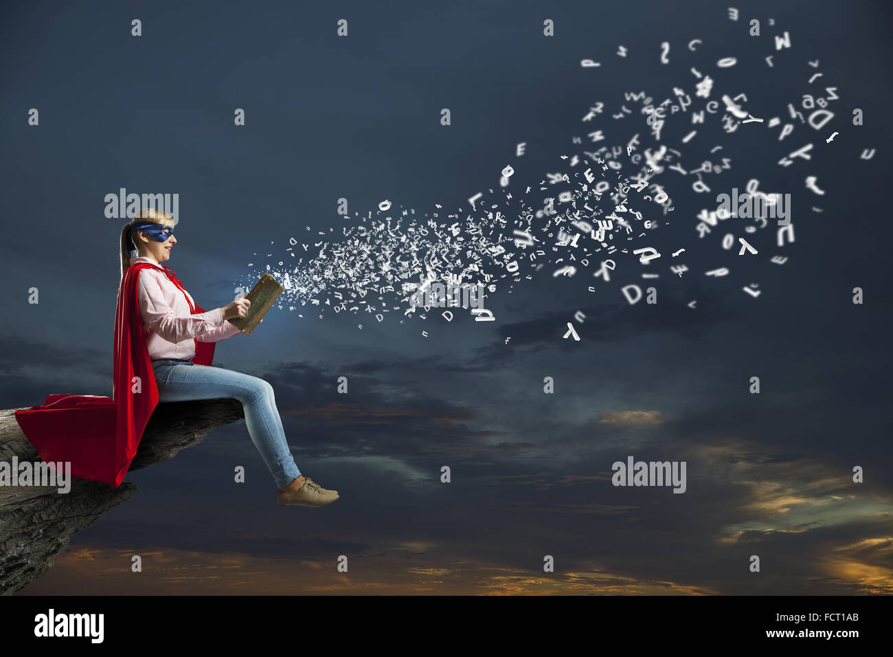 Young woman in super hero costume reading book hi-res stock photography ...